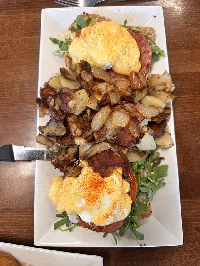 Benedict perfection: poached eggs perched atop savory goodness, surrounded by a battalion of home fries ready to soak up every drop of hollandaise.