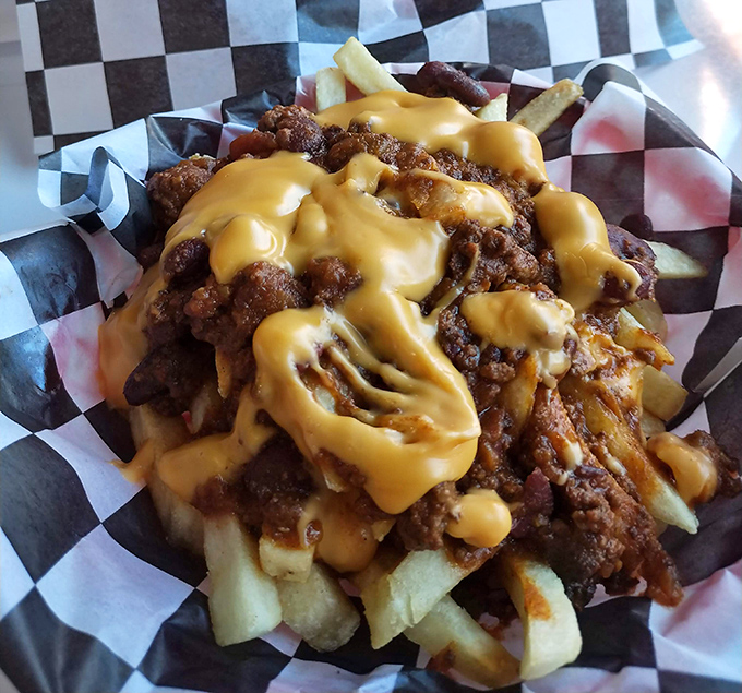 These loaded fries aren't just a side dish—they're a main event draped in cheese sauce that flows like molten gold.
