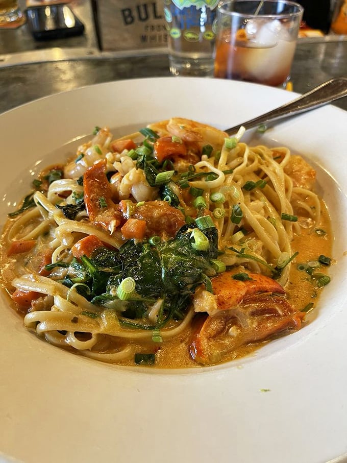 Seafood pasta that's having an identity crisis—is it comfort food or gourmet cuisine? With plump shrimp and fresh greens swimming in that sauce, who cares about labels?