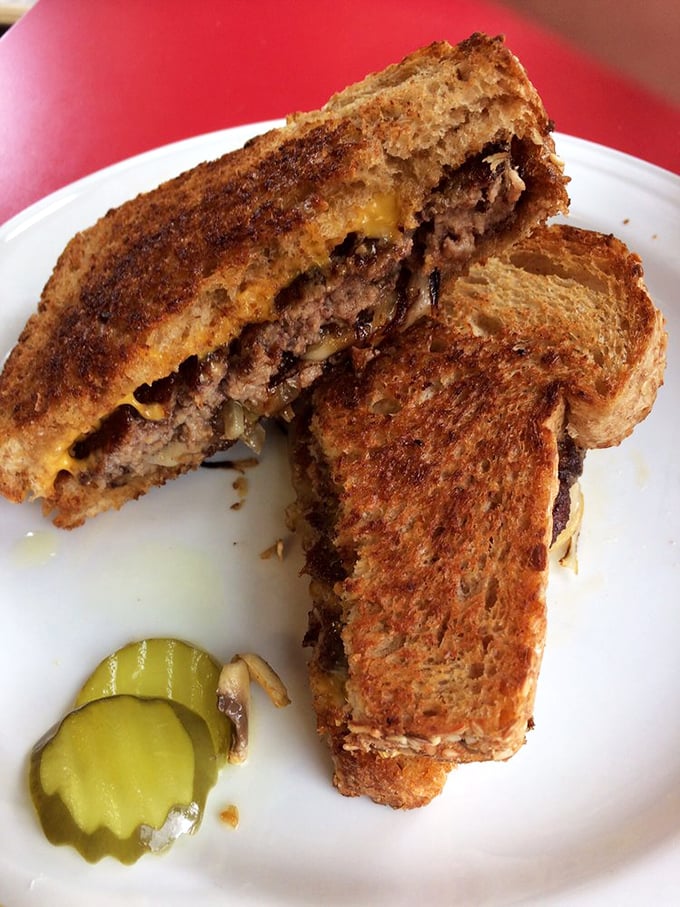 The patty melt—that brilliant marriage of burger and grilled cheese—arrives with perfectly caramelized onions hiding between layers of melted cheese and toasty bread.