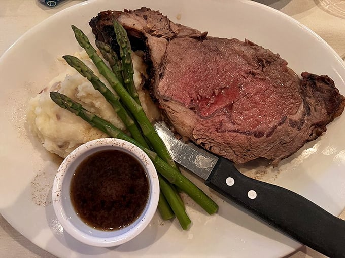Behold the prime rib in all its glory—a carnivore's dream with that telltale pink center, served with au jus that's practically liquid gold.