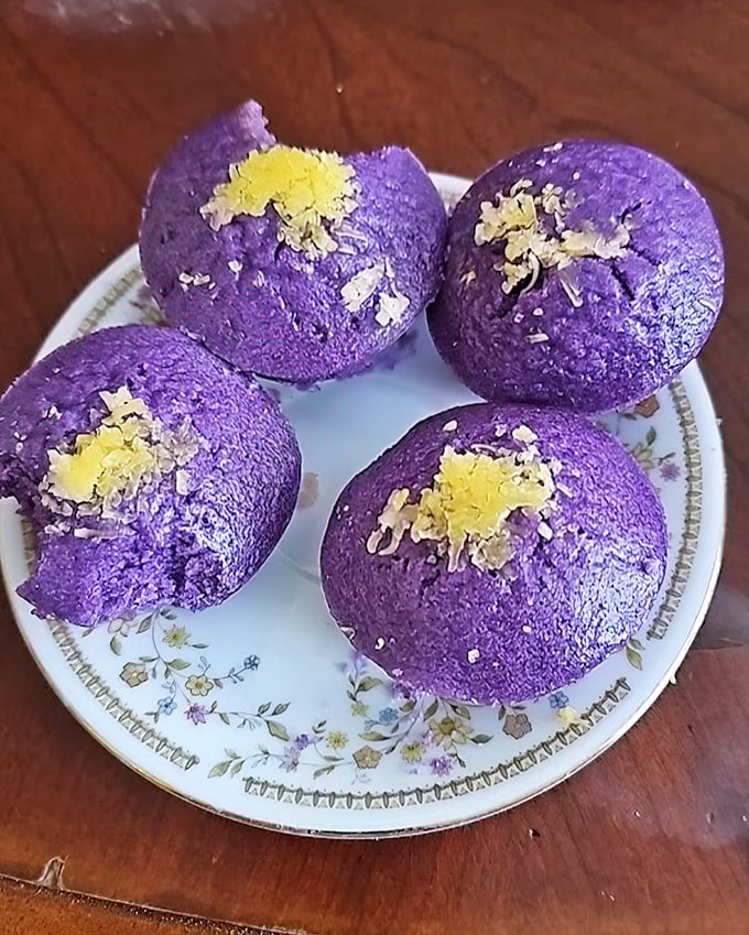 These vibrant purple puto (rice cakes) aren't just dessert, they're edible art – like little purple planets dusted with cheese that landed on your plate. 