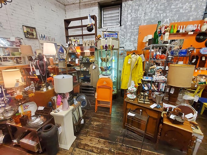 A retro-lover's dream corner where mid-century lamps illuminate collections of vintage treasures against whitewashed brick walls that have seen it all.