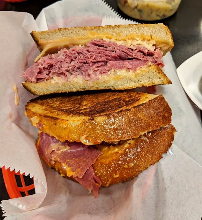 Behold the Reuben in its natural habitat—a perfect marriage of corned beef, sauerkraut, and melted Swiss. Architecture you can eat!