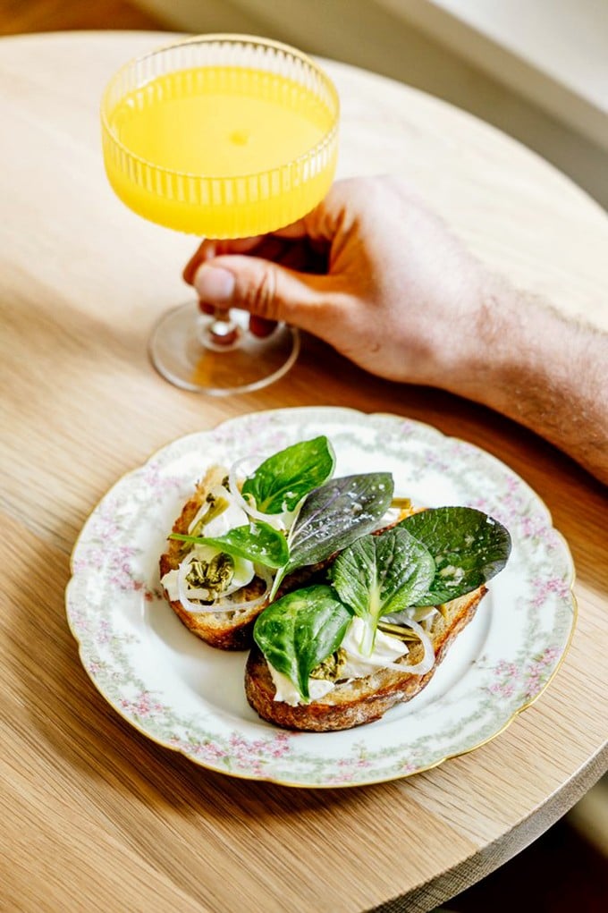 Ricotta toast elevated to art form with tender greens and a mimosa that practically glows with fresh-squeezed promise.