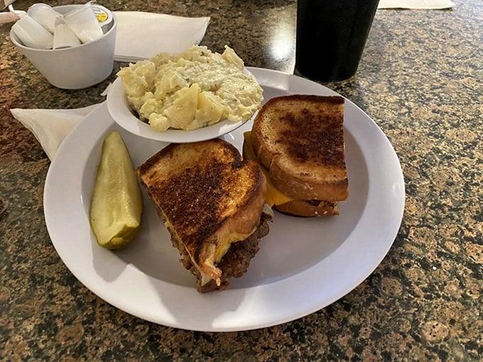 A proper diner patty melt—where buttery grilled bread meets melted cheese and beef in a harmonious union that transcends fast food.