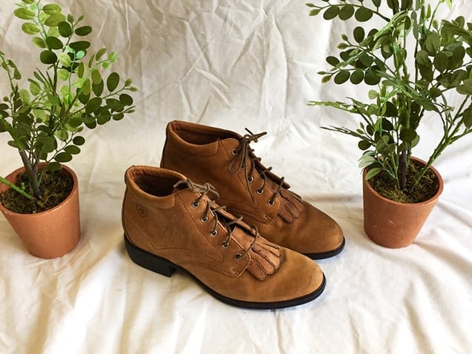 These leather ankle boots flanked by potted plants aren't just footwear—they're the beginning of your "I can't believe these were secondhand" fashion story.