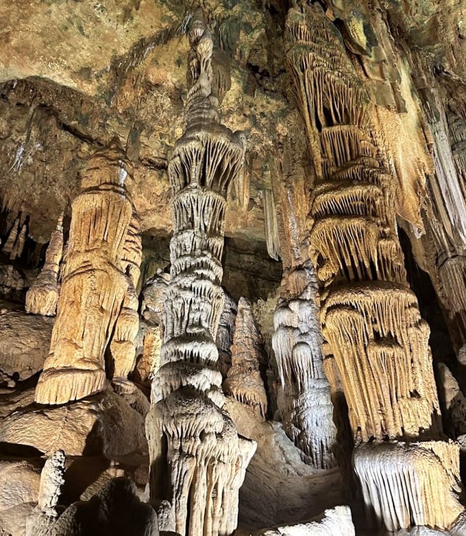 A visitor pauses to appreciate nature's handiwork, standing before stone curtains that took longer to create than human civilization has existed.