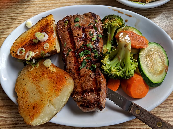 Steak night done right—perfectly seared, knife standing by, with vegetables pretending they're the reason you ordered this plate.