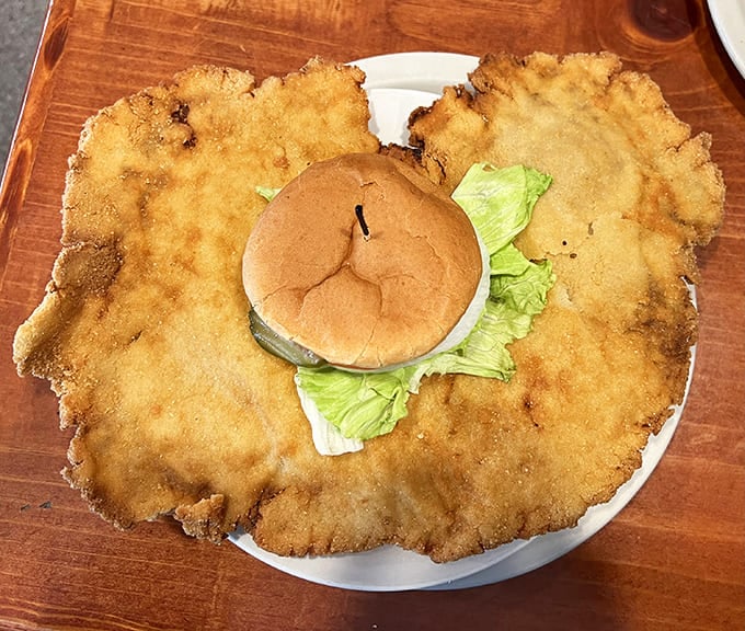 The tenderloin sandwich has clearly escaped the boundaries of its bun, like a delicious protest against conventional sandwich architecture.