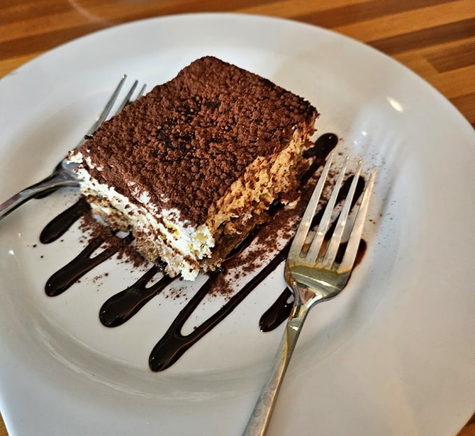 The tiramisu that launched a thousand road trips—perfectly dusted with cocoa and drizzled with chocolate that makes resistance futile.