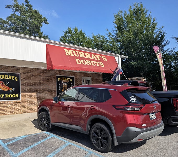 The classic red awning and brick building look exactly like what a perfect donut shop should be.
