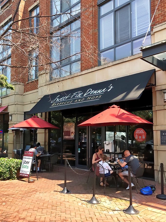 Those red umbrellas aren't just pretty; they're shading some of the finest barbecue conversations in Alexandria.