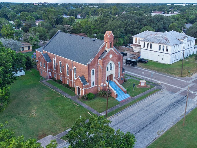 Red brick church and white buildings create a picture-perfect scene of small-town Texas charm.