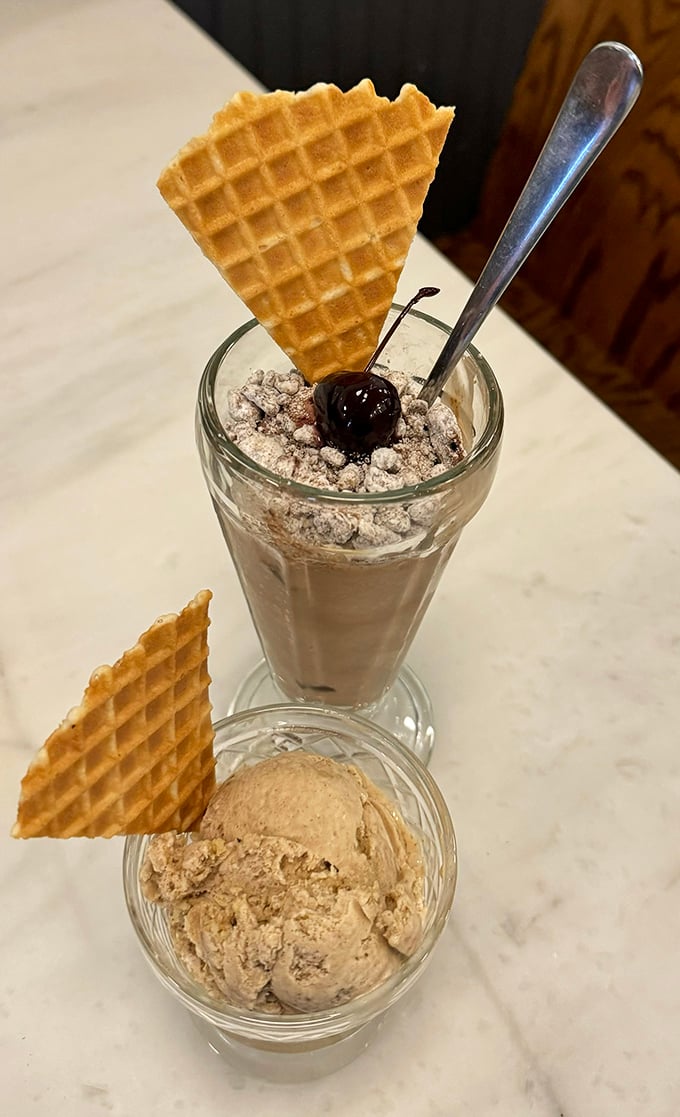 A perfect pairing: creamy ice cream in a glass with a waffle garnish meets its soulmate—a scoop in a dish that's patiently waiting its turn.