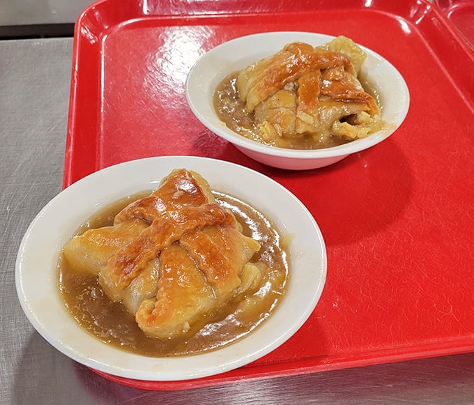 These apple dumplings aren't just dessert—they're edible nostalgia, wrapped in flaky pastry and swimming in a cinnamon-spiced sauce that demands to be savored.