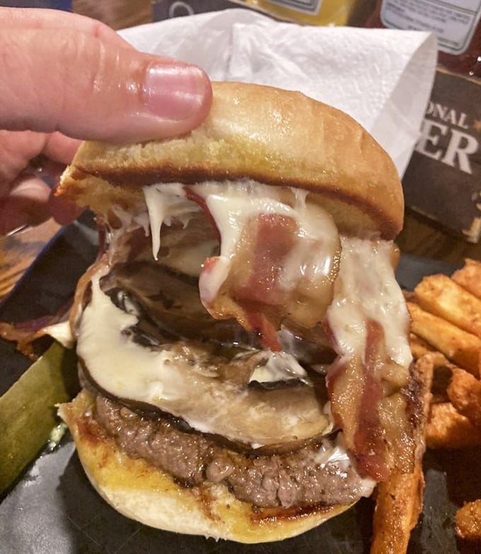 Melty cheese cascades over bacon and mushrooms like a savory waterfall. This isn't just a burger—it's architecture you can eat.