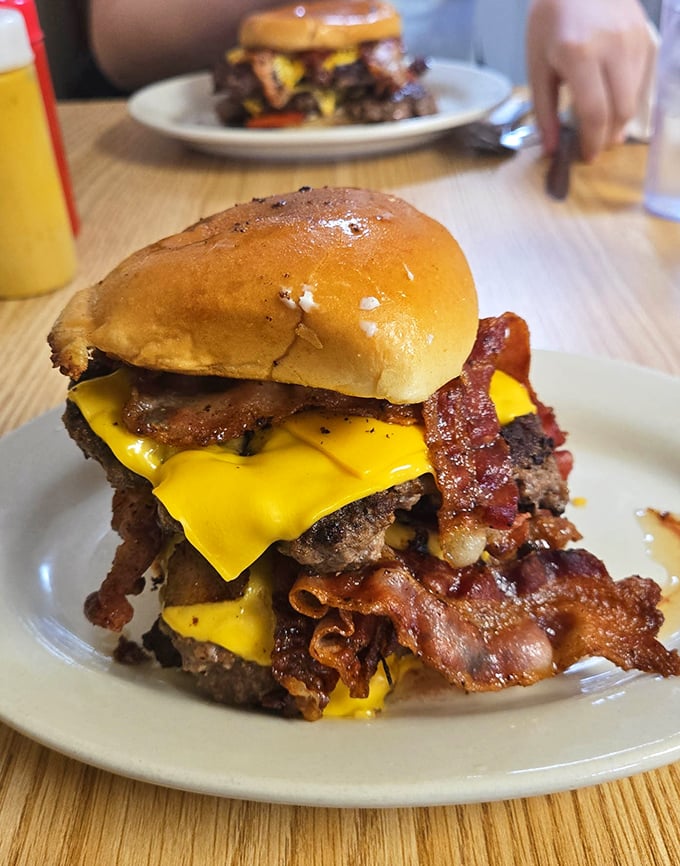 The burger that launched a thousand napkins—layers of bacon, cheese, and beef stacked so high you'll need to strategize your approach.