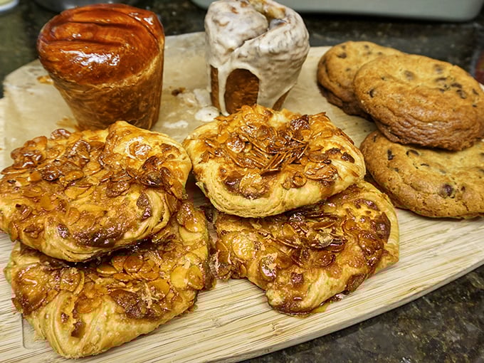 A wooden board of temptation featuring caramelized kouign-amann, cookies, and what appears to be pastry nirvana in various forms.