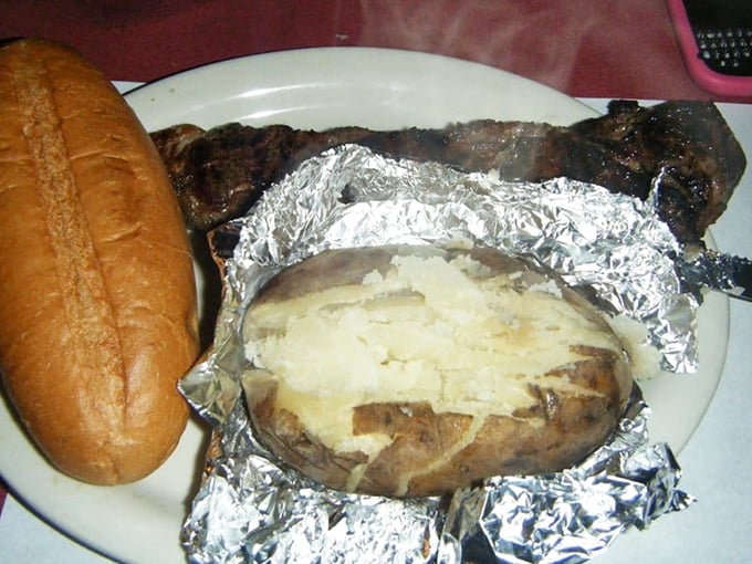 The humble baked potato, wrapped in its silver evening wear, waits patiently beside a steak and bread that could make an Italian gondolier weep with joy.