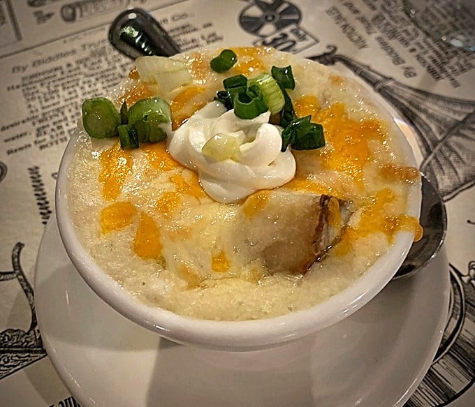 Not all heroes wear capes—some wear cheese, green onions, and bacon bits while swimming in a bowl of potato perfection.