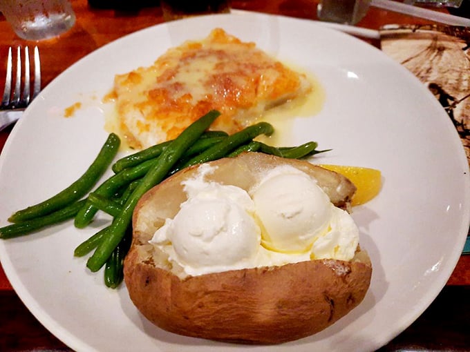 A loaded baked potato alongside perfectly cooked fish and green beans – the comfort food trifecta. This plate says "vacation" without a word.