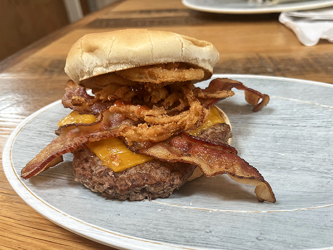 This isn't just a burger—it's an engineering marvel of beef, bacon, cheese, and onion rings that requires both hands and possibly a nap afterward.