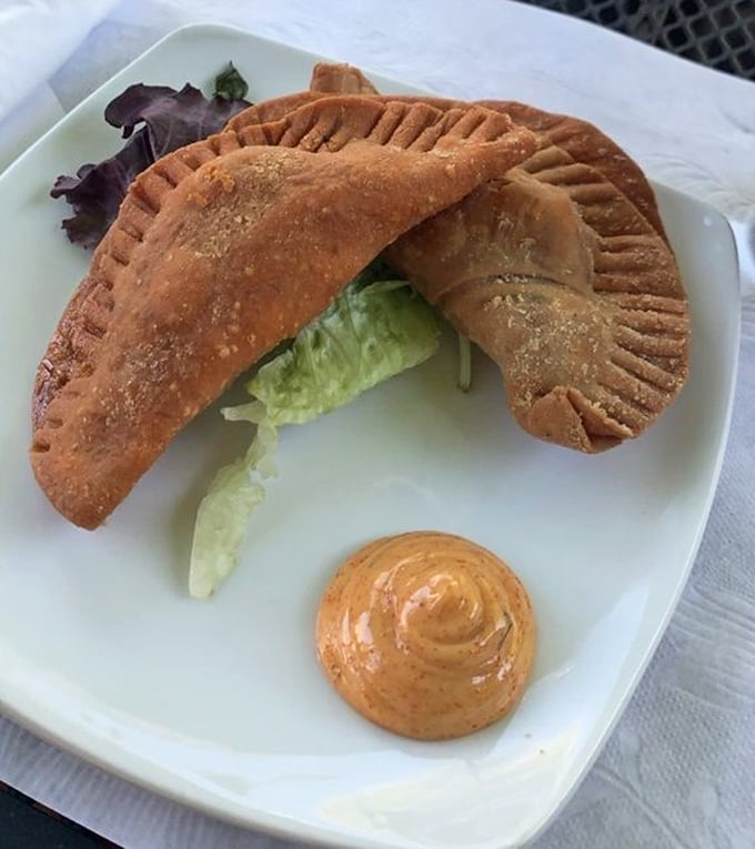 These empanadas aren't just stuffed—they're blessed with a perfectly crimped edge and golden crust. The accompanying sauce adds a tangy exclamation point.