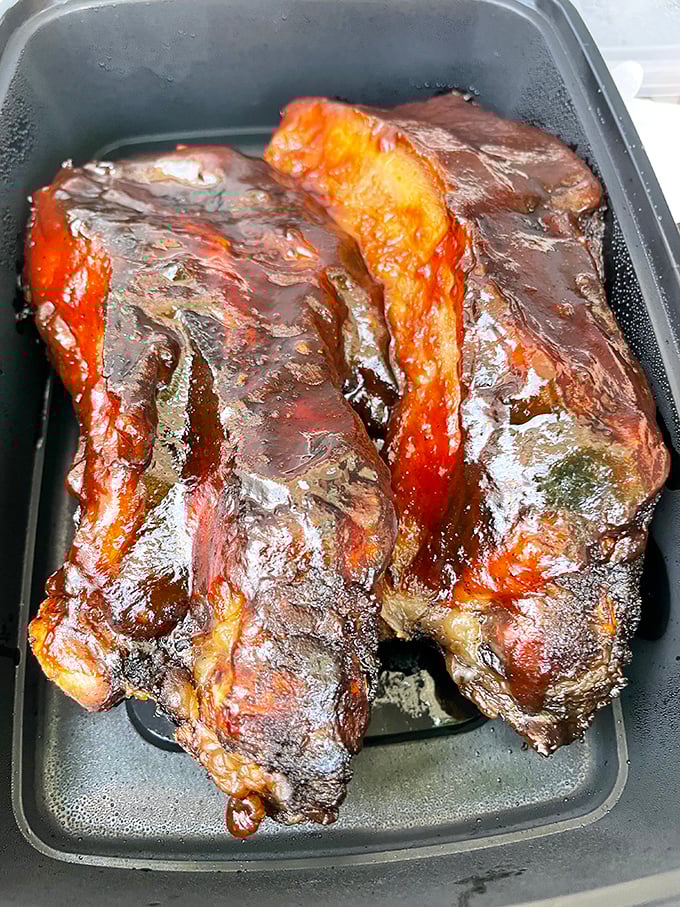 These beef ribs aren't just dinner; they're prehistoric-looking meat lollipops glazed to a mahogany shine that would make furniture jealous.