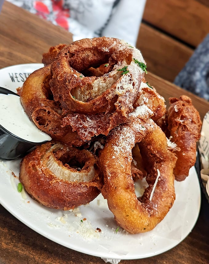 Beer-battered onion rings stacked like golden halos, proving that some foods are worth the inevitable food coma.