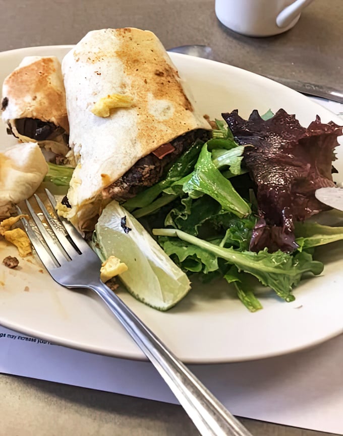 This breakfast burrito isn't just a meal, it's a morning masterpiece wrapped in a tortilla, served with a side of fresh greens.
