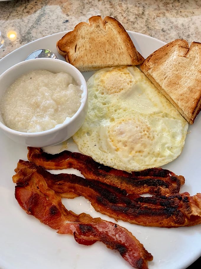 The breakfast trinity: perfectly cooked eggs, bacon with just the right crispness, and grits that would make any Southerner nod in approval.
