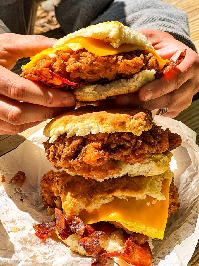 Layer upon layer of breakfast bliss – crispy fried chicken, melty cheese, and bacon all nestled between halves of that legendary biscuit. Worth every calorie.