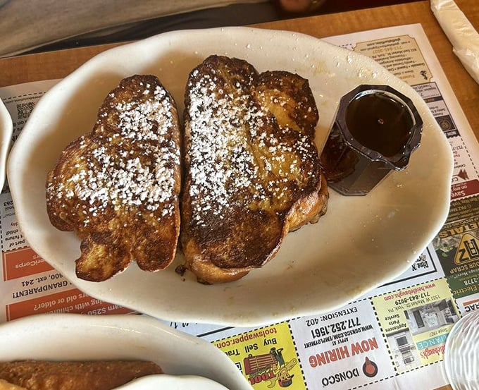 French toast that's achieved celebrity status—golden, dusted with powdered sugar, and waiting for its maple syrup paparazzi moment.