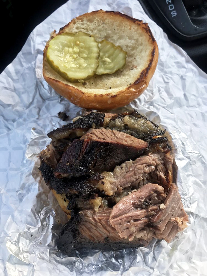 Behold the brisket sandwich – where smoke-kissed meat meets pickle chips in a romance more compelling than any Hollywood blockbuster.