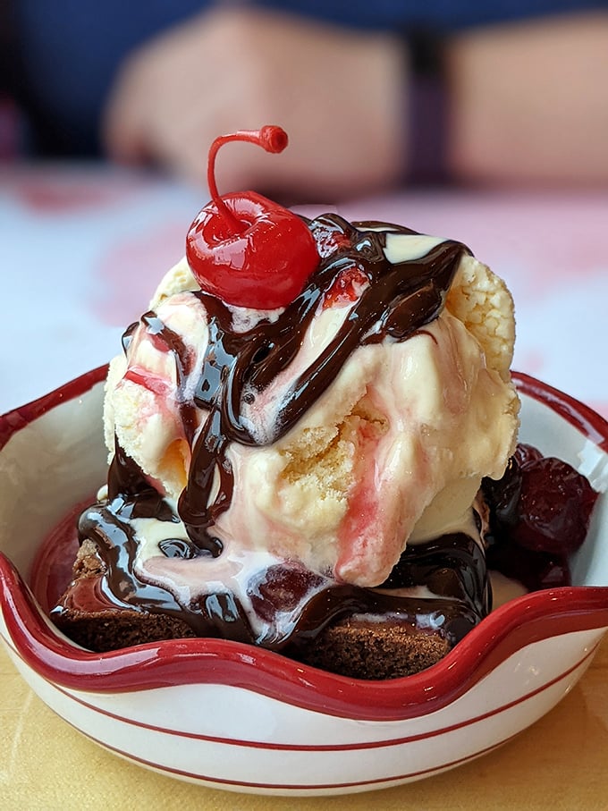 This brownie sundae isn't just dessert—it's architecture, sculpture, and pure joy topped with a cherry that actually deserves to be there.