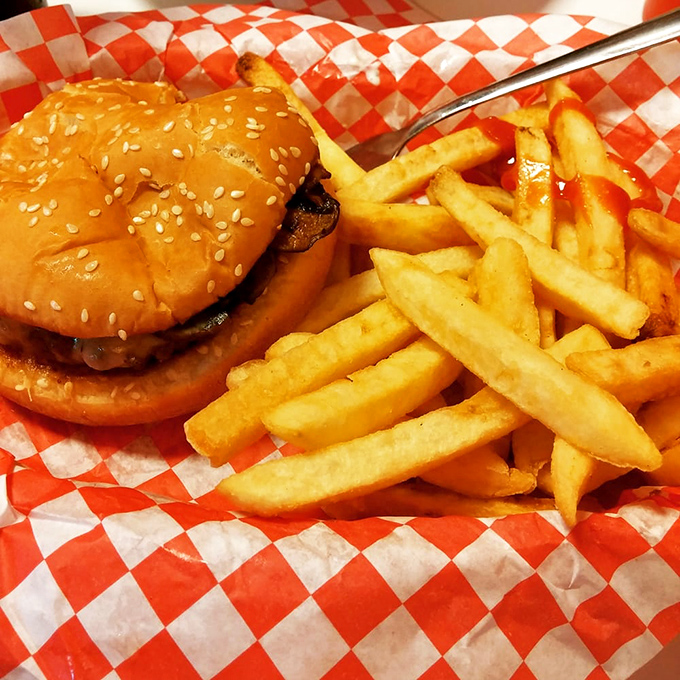 A burger and fries on a red-checkered paper—proof that happiness doesn't need white tablecloths or servers who introduce themselves as "your guide."