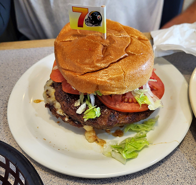 This burger isn't just wearing a Steelers flag—it's declaring itself MVP-worthy with a perfectly charred patty and garden-fresh toppings. Tailgate dreams realized.