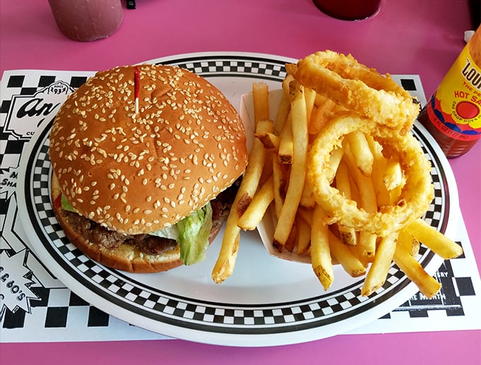 The burger arrives with an entourage of golden fries and onion rings—a reminder that simplicity, when done right, needs no improvement.