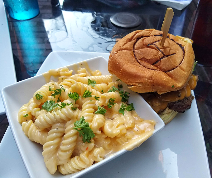 The burger arrives with a side of mac and cheese so good you'll debate which deserves your attention first—a delicious dilemma indeed.