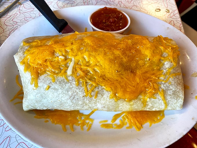 This breakfast burrito isn't messing around—it's a cheese-crowned behemoth that requires both hands and possibly a nap afterward.
