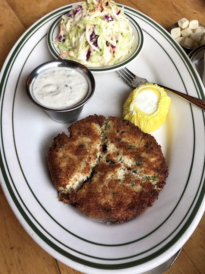 This golden-crusted crab cake isn't hiding behind fillers—it's almost all crab, crispy outside and sweet within, served with classic accompaniments that let the seafood shine.