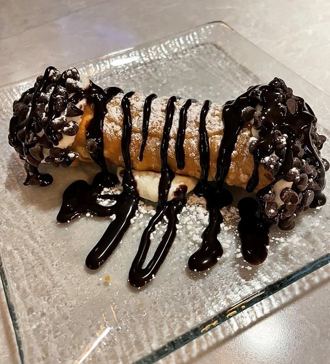 The infamous cannoli in all its glory—chocolate-dipped ends, powdered sugar dusting, and that chocolate drizzle that's worth every mile of the drive.