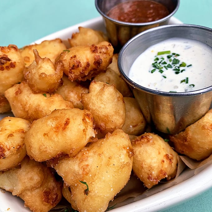These cheese curds aren't just fried—they're transformed into golden pillows of Wisconsin pride that squeak with every heavenly bite.
