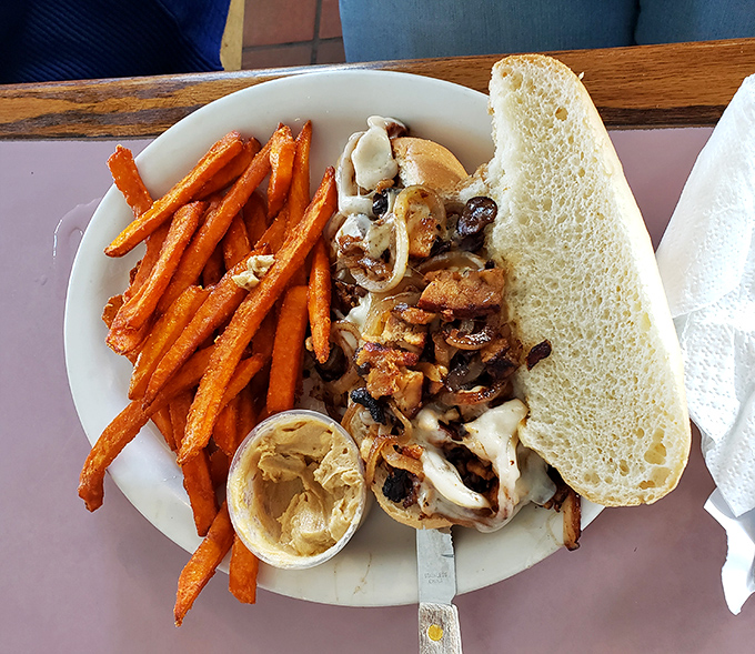 A sandwich that doesn't just satisfy hunger—it negotiates peace between sweet potato fries and savory fillings with diplomatic deliciousness.