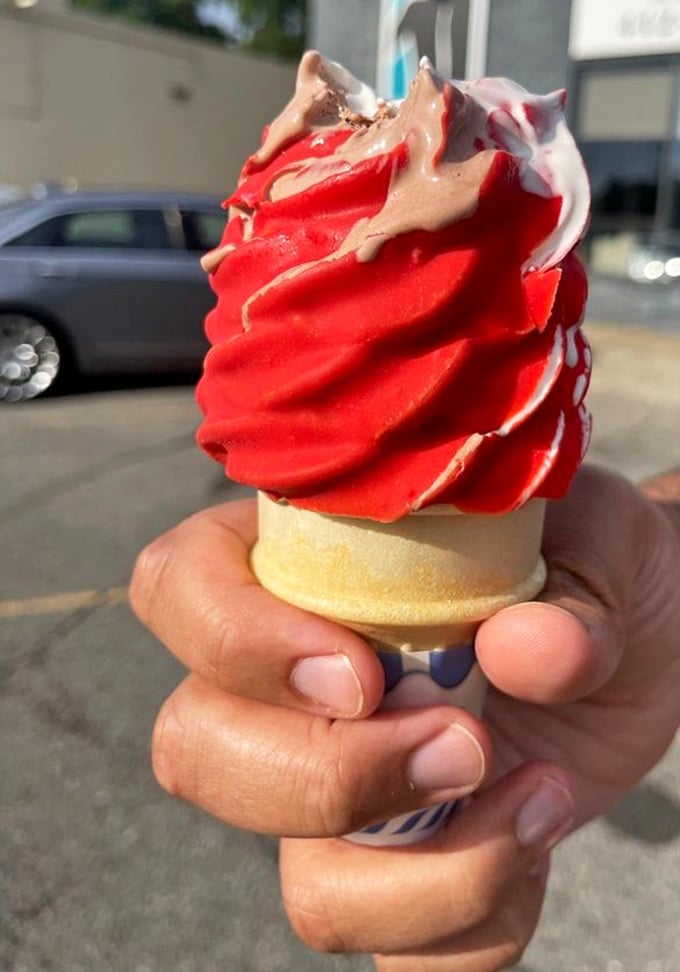 This red twist soft serve with vanilla drizzle isn't just a cone—it's edible architecture that demands to be admired before devoured.