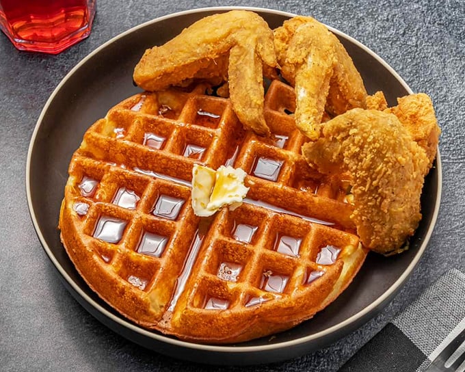 Chicken and waffles: the breakfast-dinner mashup that proves some of the best relationships are unexpected ones. That maple syrup river? Pure genius.
