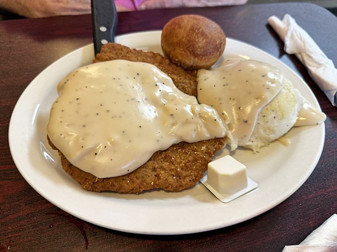 This chicken fried steak swimming in creamy pepper gravy isn't just a meal – it's a Southern hug on a plate.