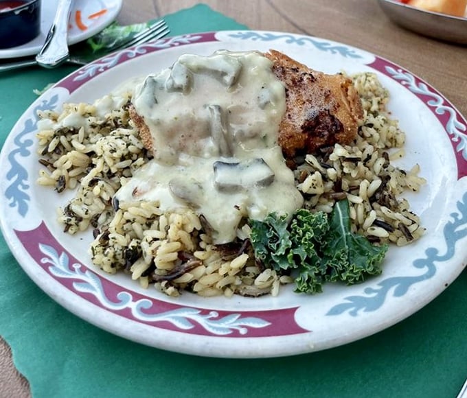 Chicken smothered in mushroom sauce atop wild rice – comfort food elevated to an art form that grandmother would approve of.