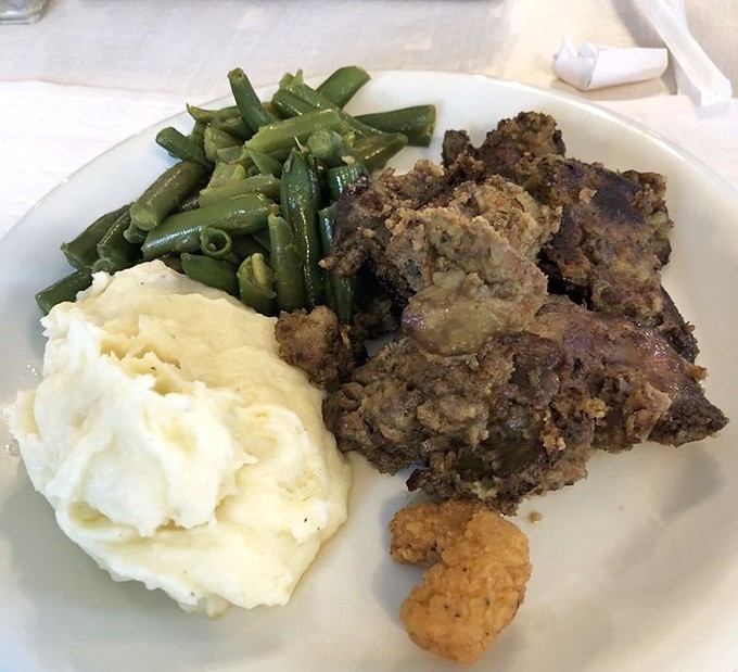 Meatloaf, mashed potatoes, and green beans—the holy trinity of comfort food arranged on a plate like edible artwork for the soul.